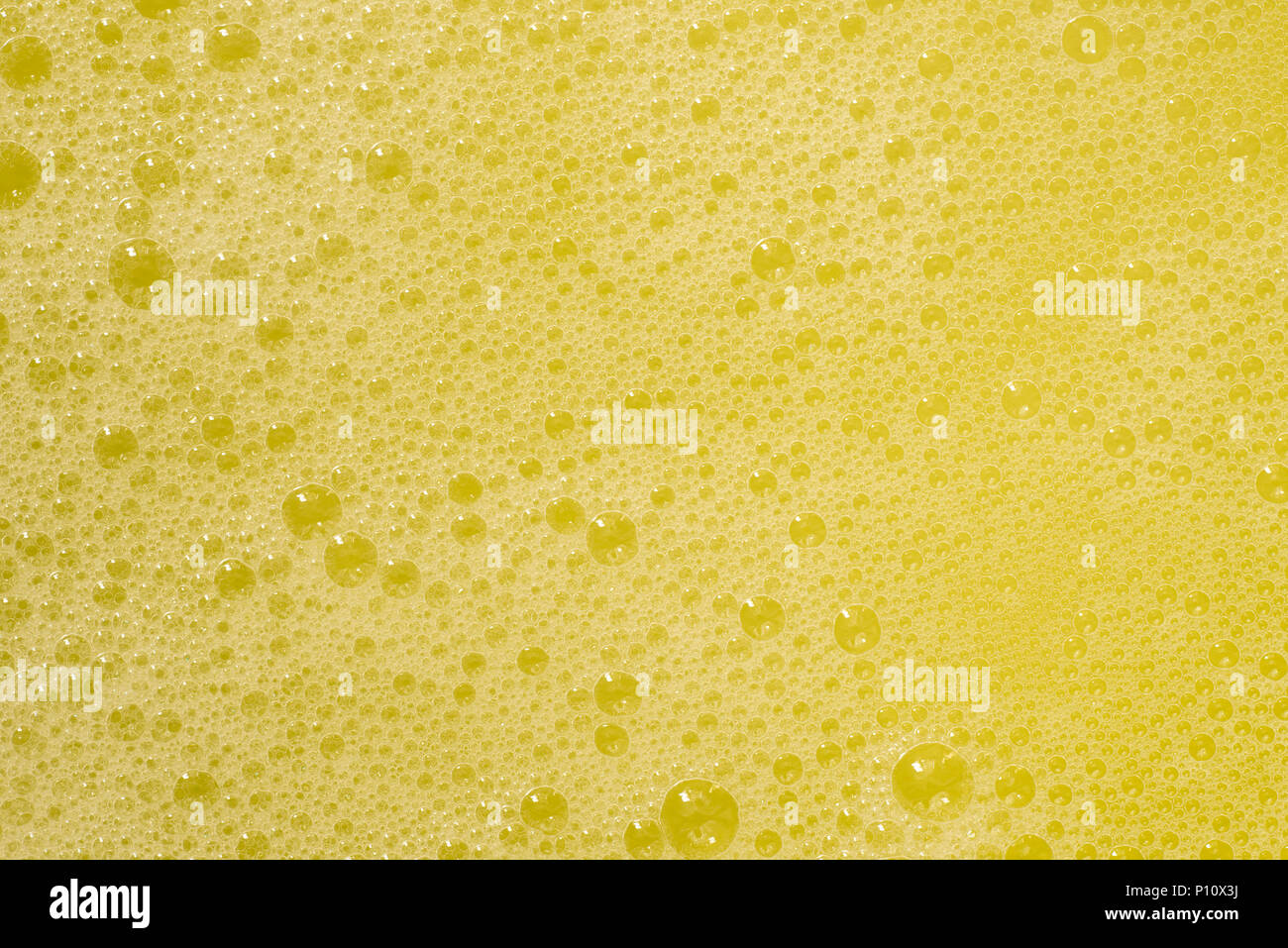 yellow washing liquid with bubbles background Stock Photo - Alamy