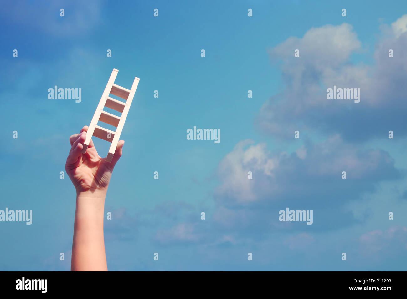 image of child hand holding a ladder against the sky. education and ...