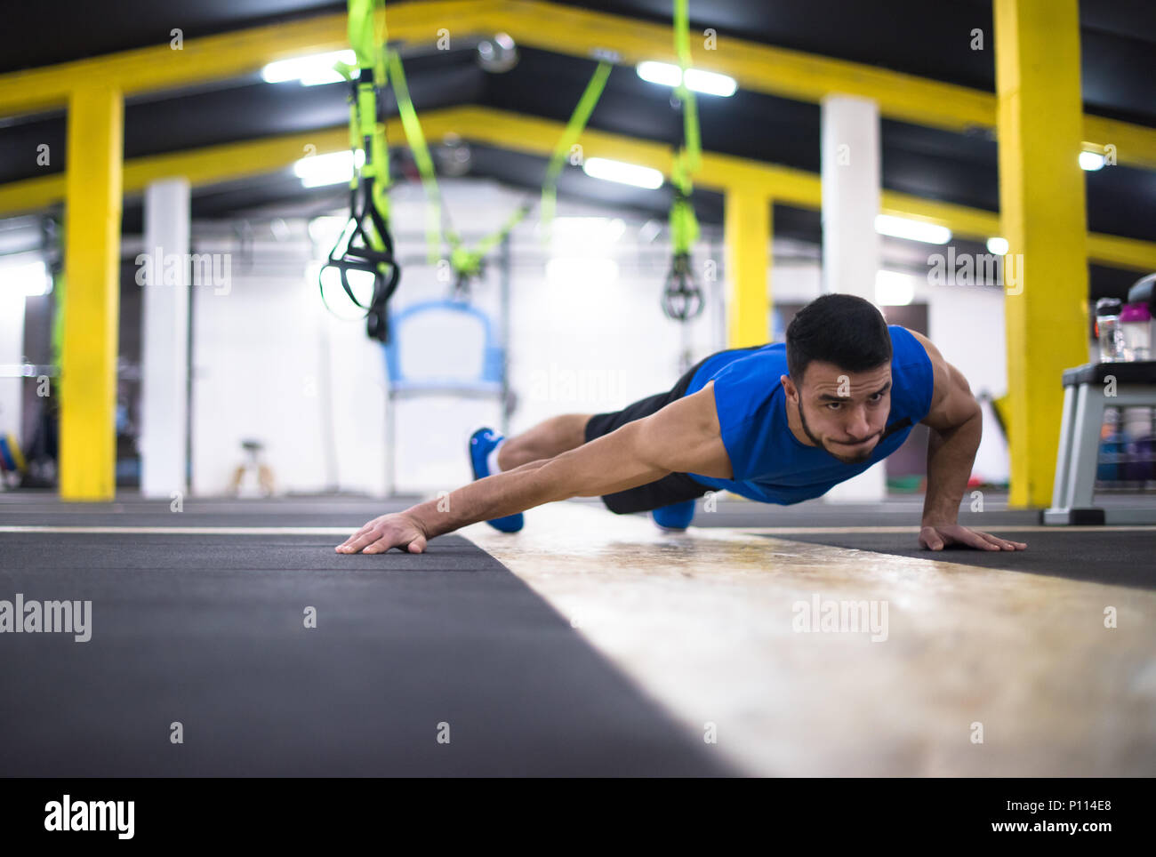 Young strong man doing pushups at cross fitness gym Stock Photo - Alamy