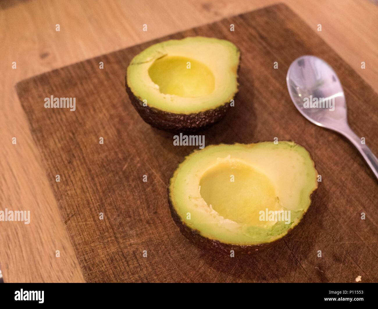 ripe avocado cut in two ready to be eaten Stock Photo - Alamy