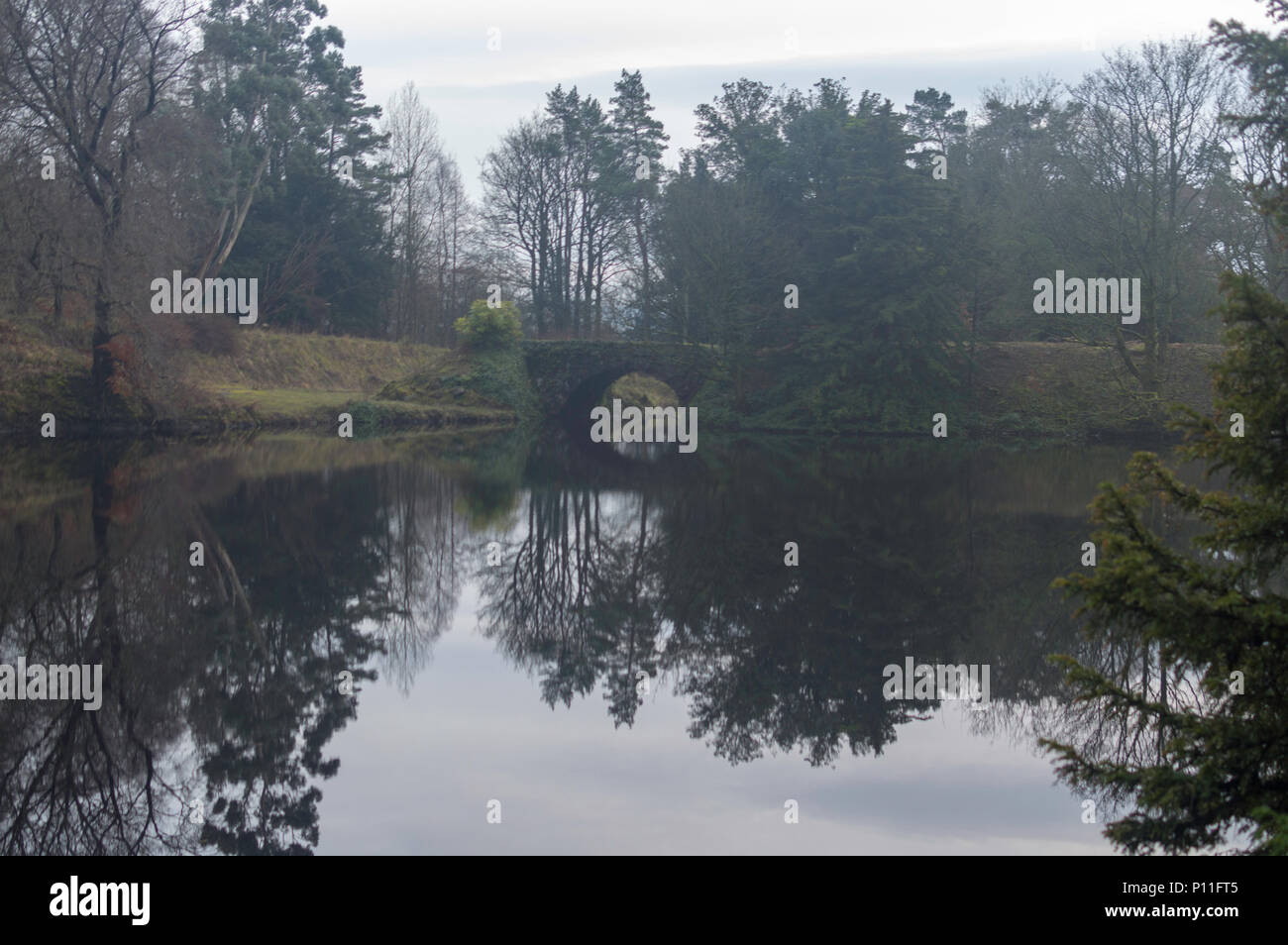 Tranquil reflection of bridge at Clapham Beck Stock Photo - Alamy