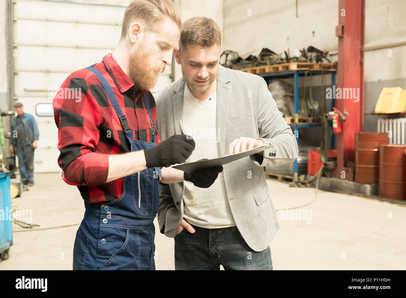 Young garage mechanic talking hi-res stock photography and images - Alamy