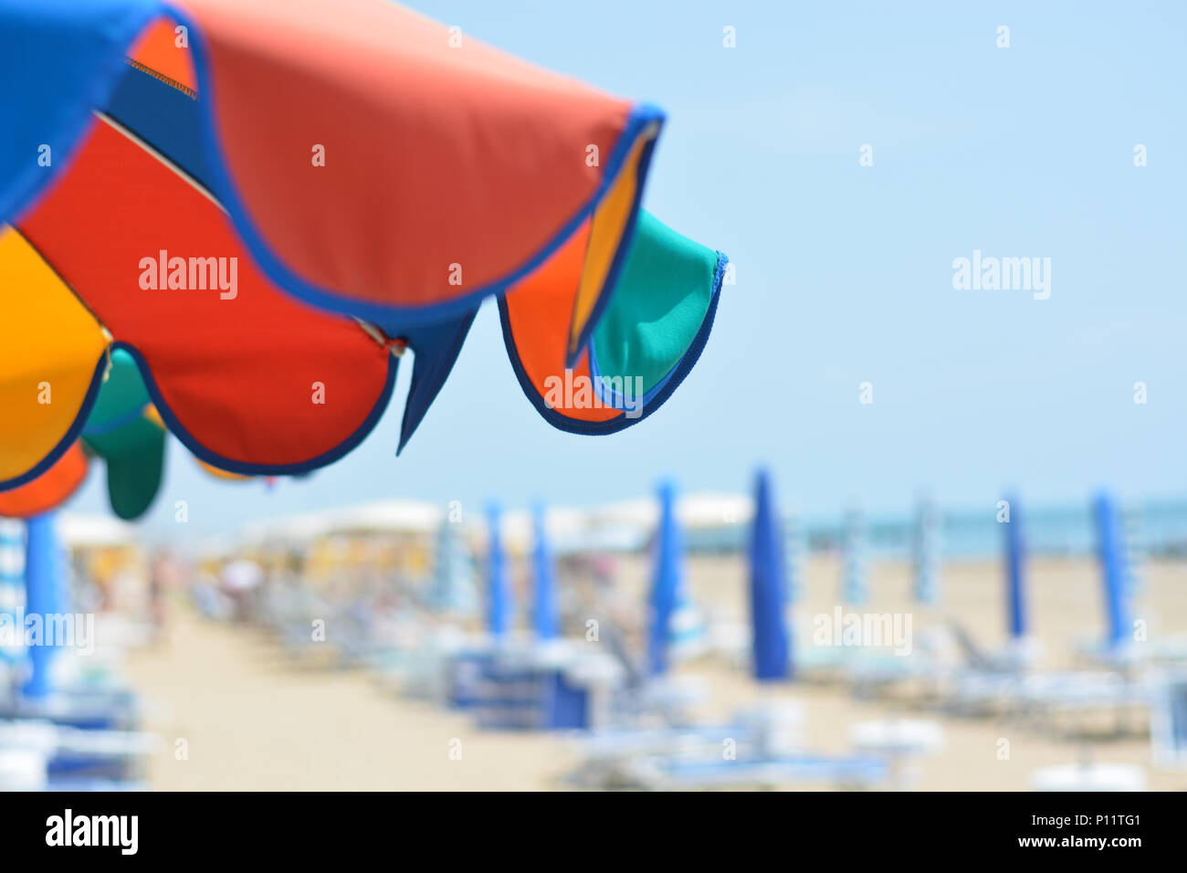 An open beach umbrella colored like the rainbow Stock Photo - Alamy