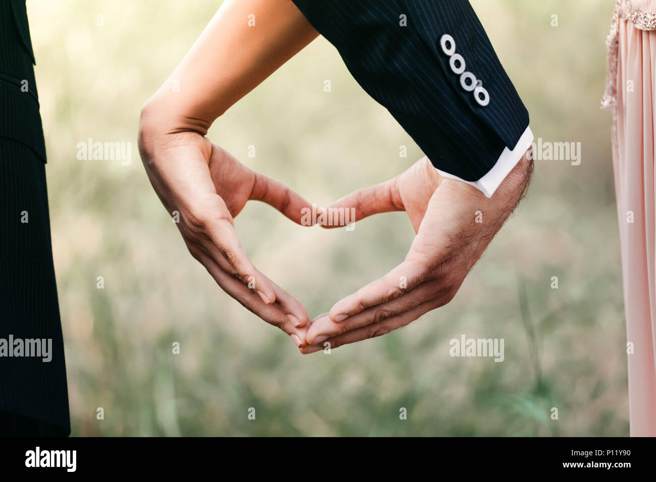 Wedding couple holding hands on green background Stock Photo - Alamy