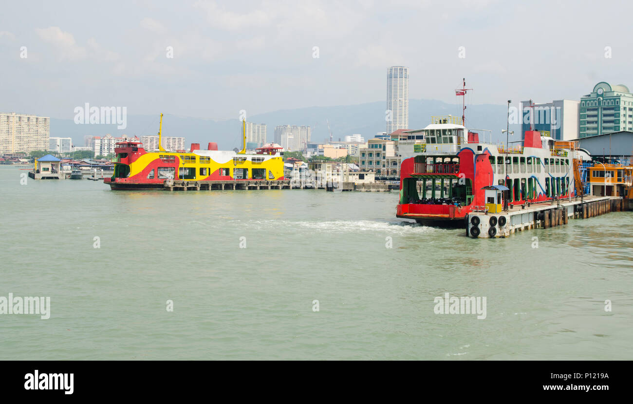 Yellow ferry with mountain and cloudy sky at background in Georgetown ...