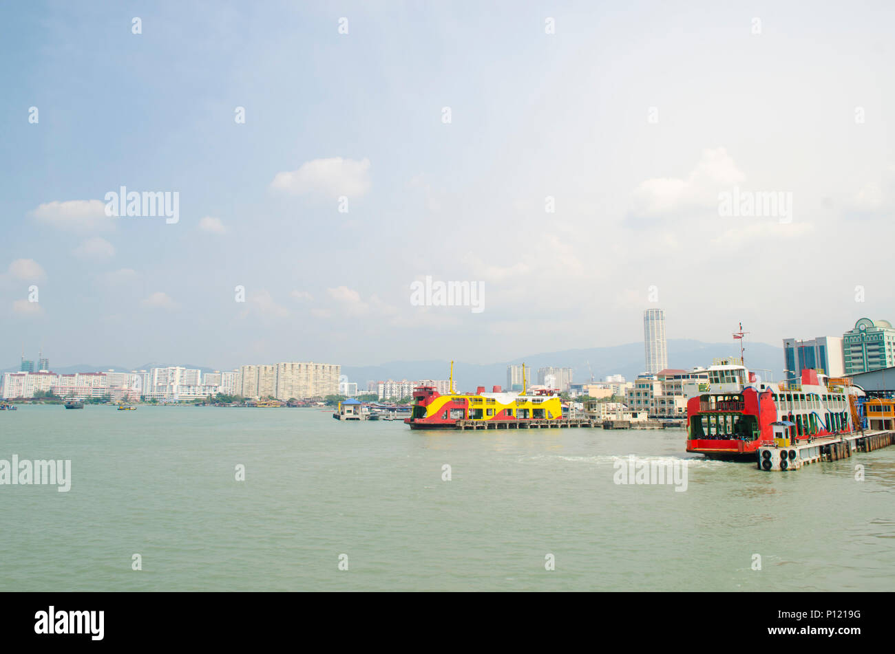 Yellow ferry with mountain and cloudy sky at background in Georgetown ...