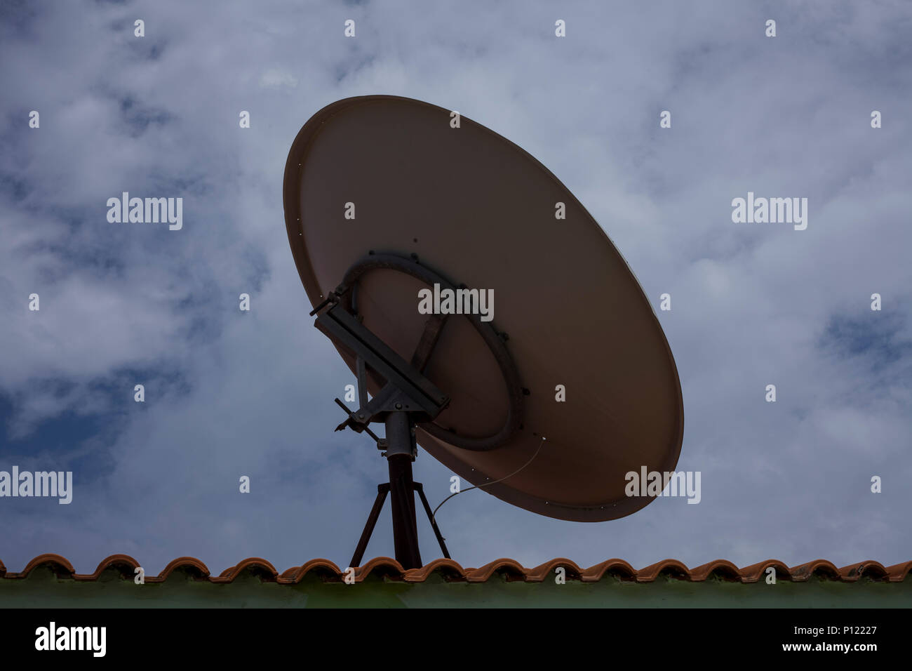 Parabolic dish antenna held on the roof top of a building. It is used by consumers to receive ...