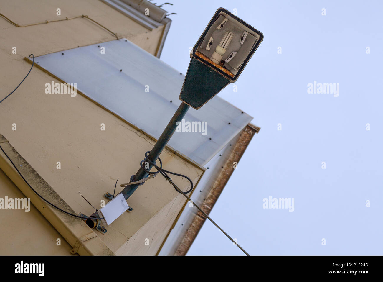 LED fixed on to a bend lamp post in front of building. The lamp post is ...