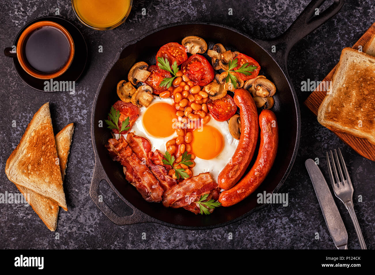 Traditional full English breakfast with fried eggs, sausages, beans ...