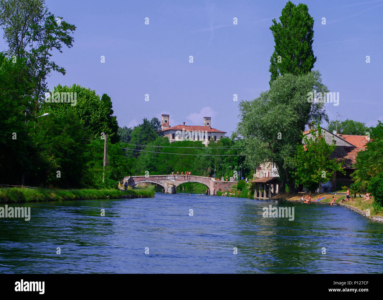 dive from the secular bridge of the Naviglio Grande in a hot summer ...