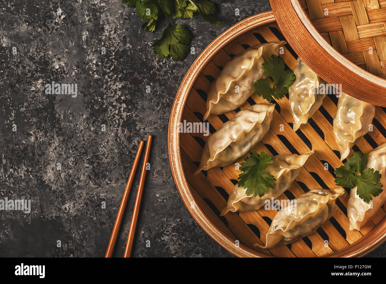 Fresh dumplings on a dark stone background. Asian cuisine, top view ...