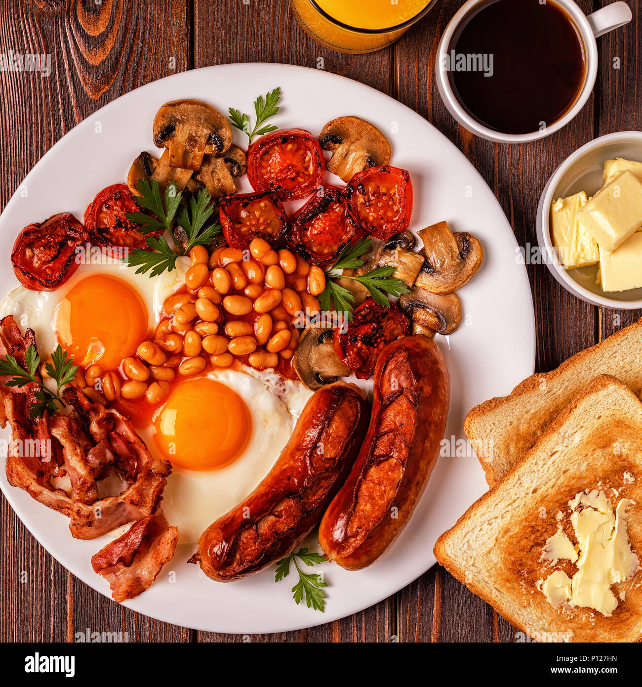 Traditional full English breakfast with fried eggs, sausages, beans ...