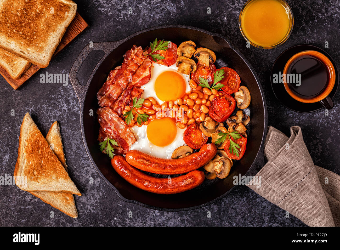 Traditional full English breakfast with fried eggs, sausages, beans ...