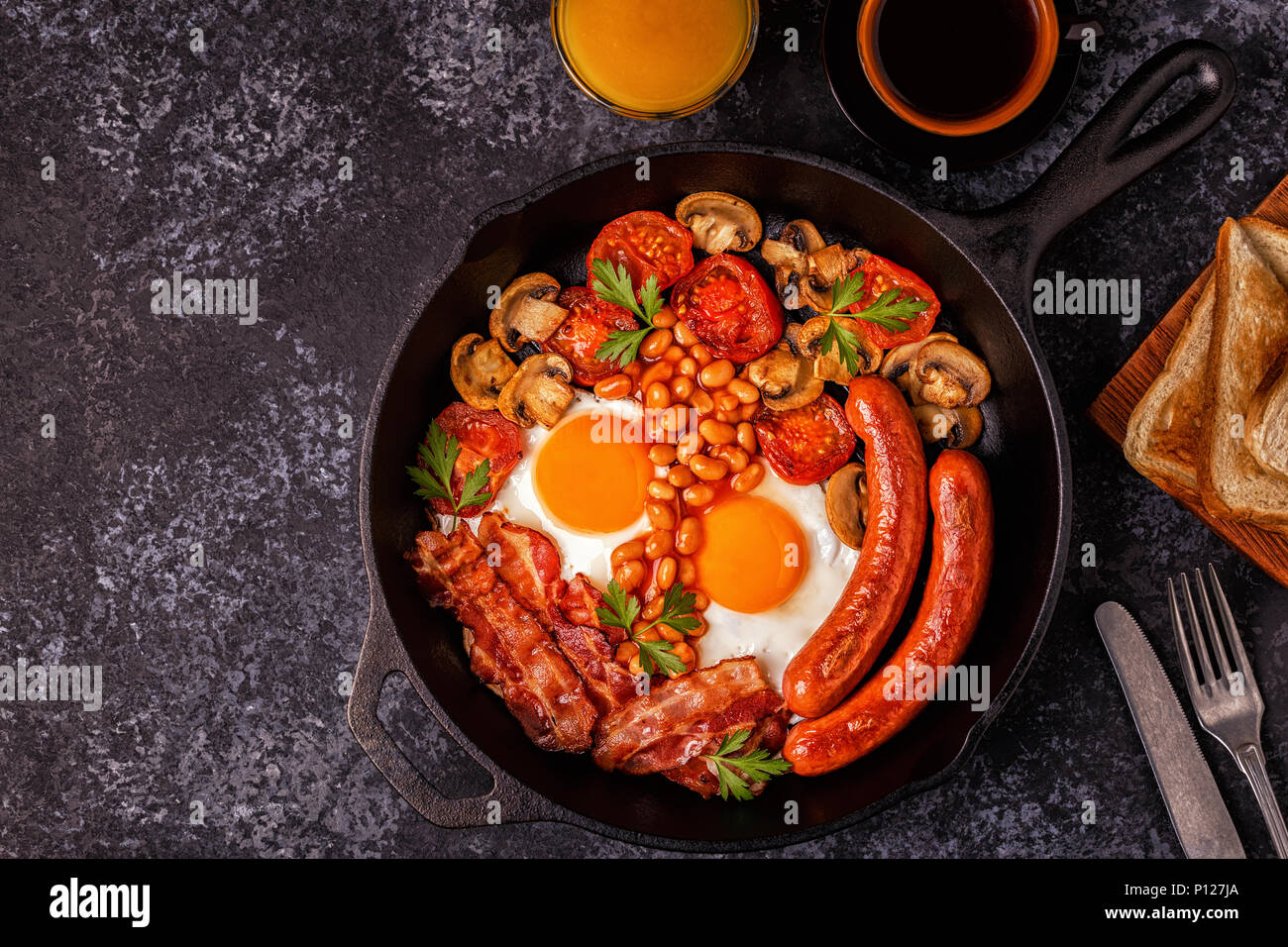 Traditional full English breakfast with fried eggs, sausages, beans ...