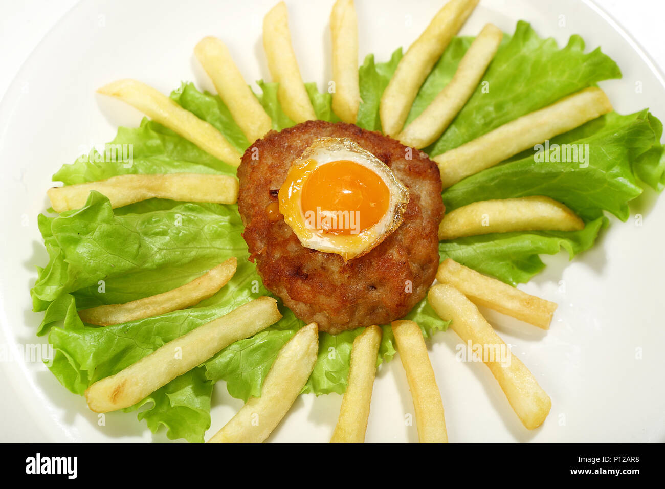 pork cutlet with French fries, green salad and quail egg Stock Photo ...