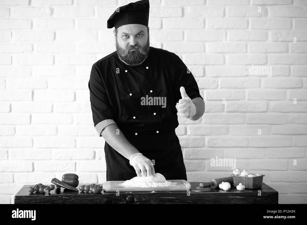 Bearded chef chef prepares meals at the table in the kitchen Stock ...