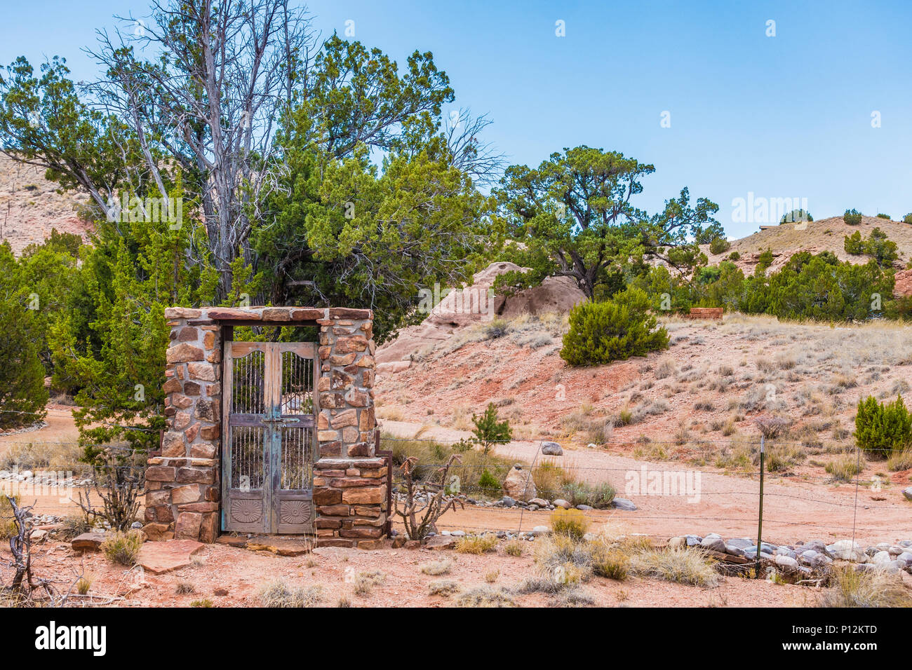 A decorative metal doorway with bars in a rock wall that is all that ...