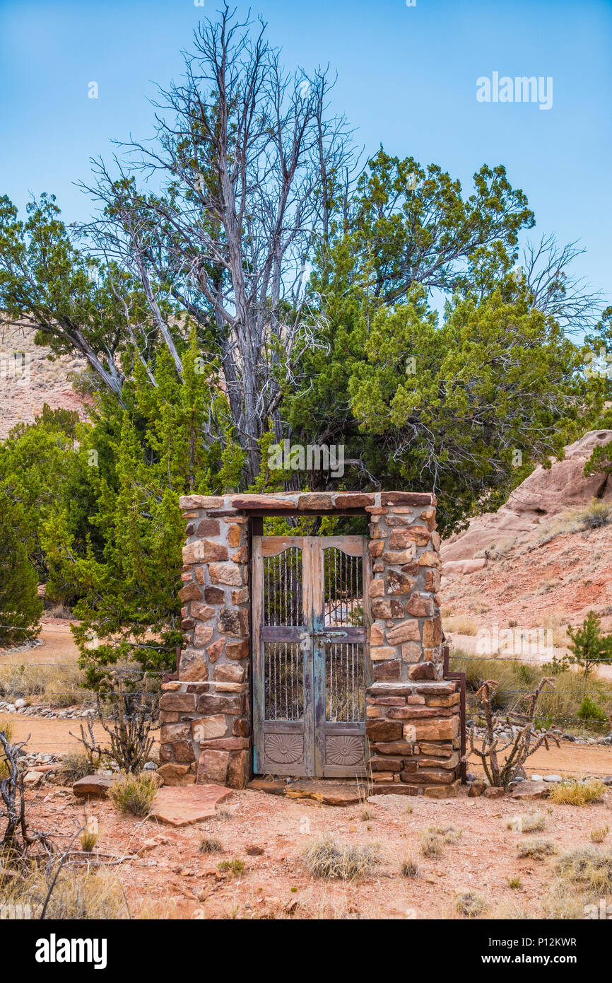 A decorative metal doorway with bars in a rock wall that is all that ...