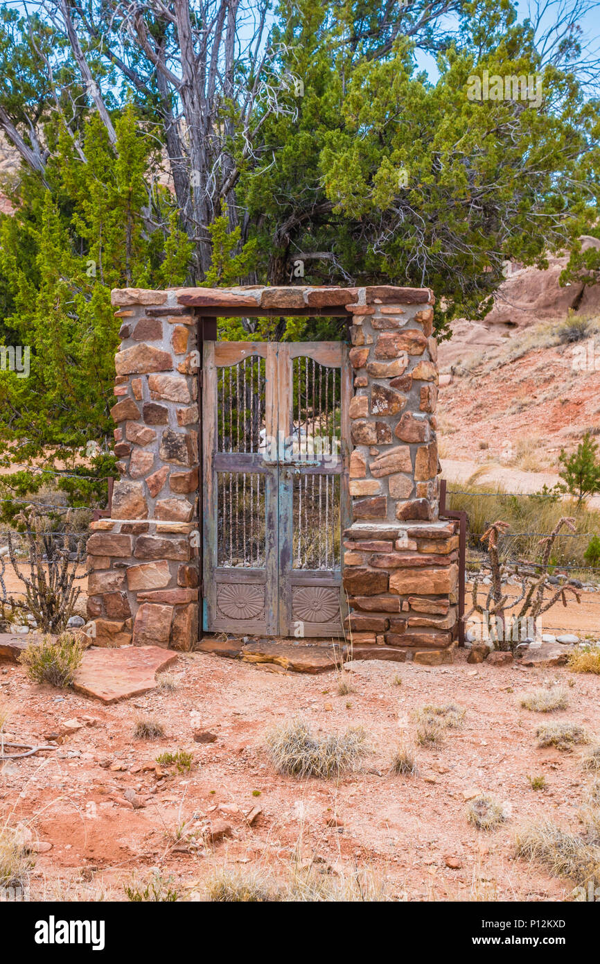 A decorative metal doorway with bars in a rock wall that is all that ...