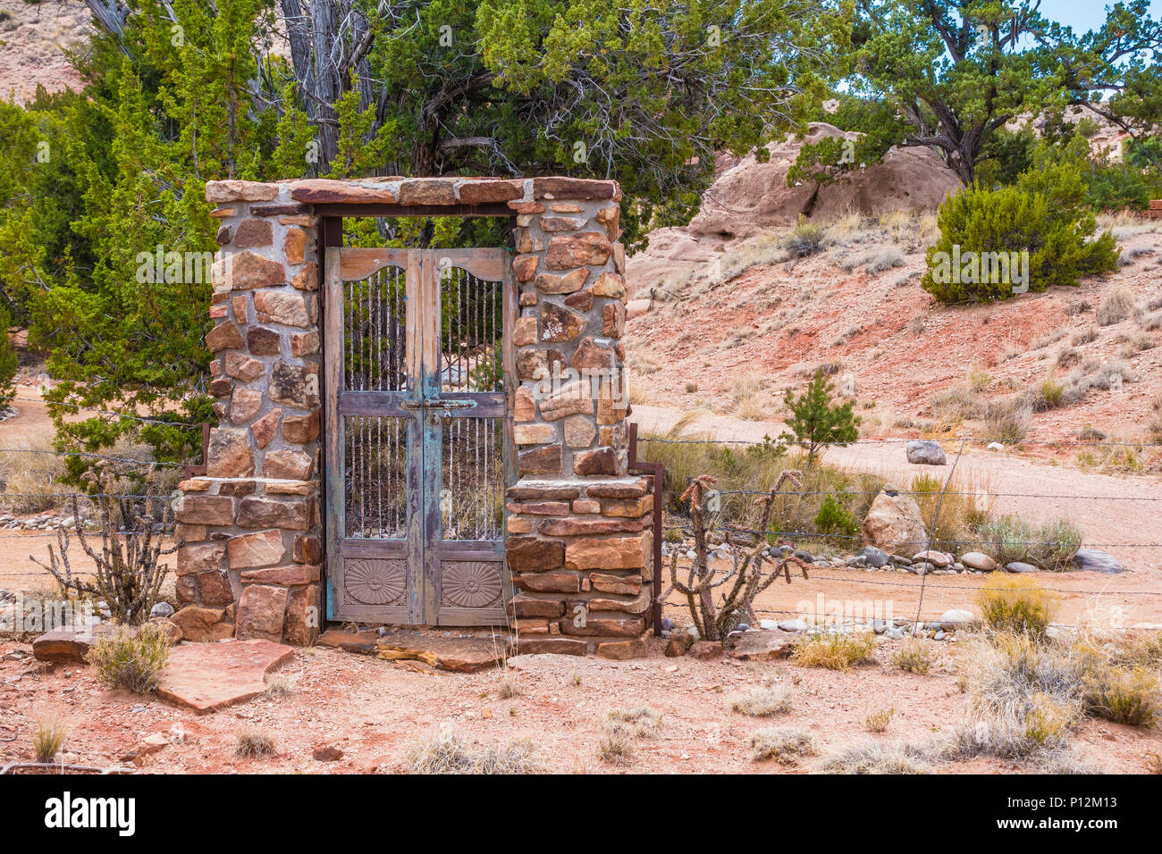 A decorative metal doorway with bars in a rock wall that is all that ...