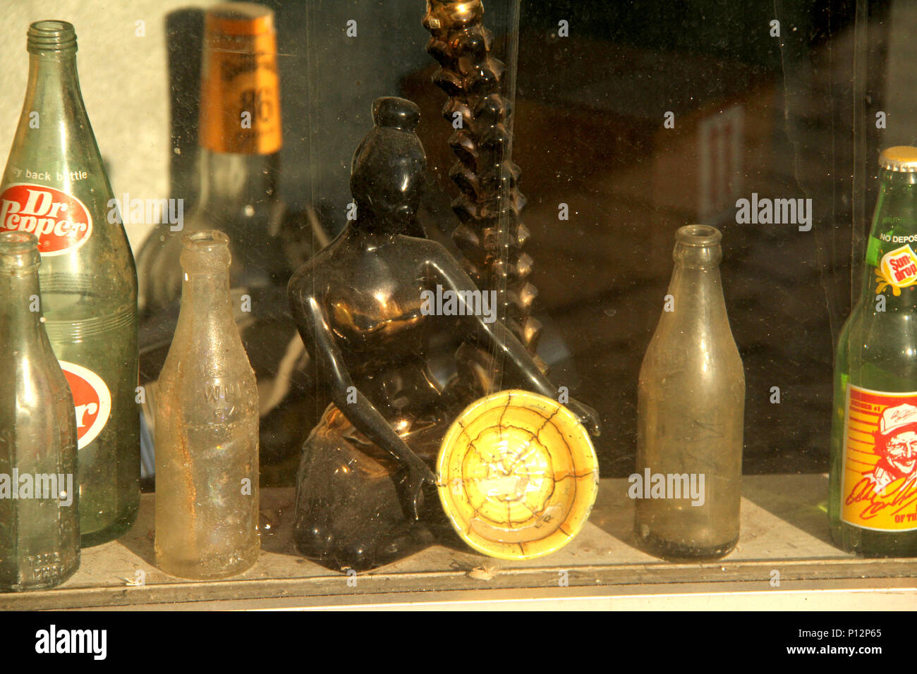 Dusty items in antique store front window Stock Photo - Alamy