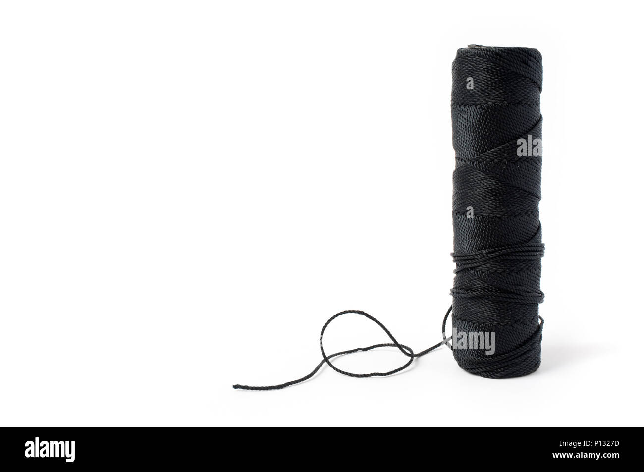 Spool of black string on white background Stock Photo - Alamy