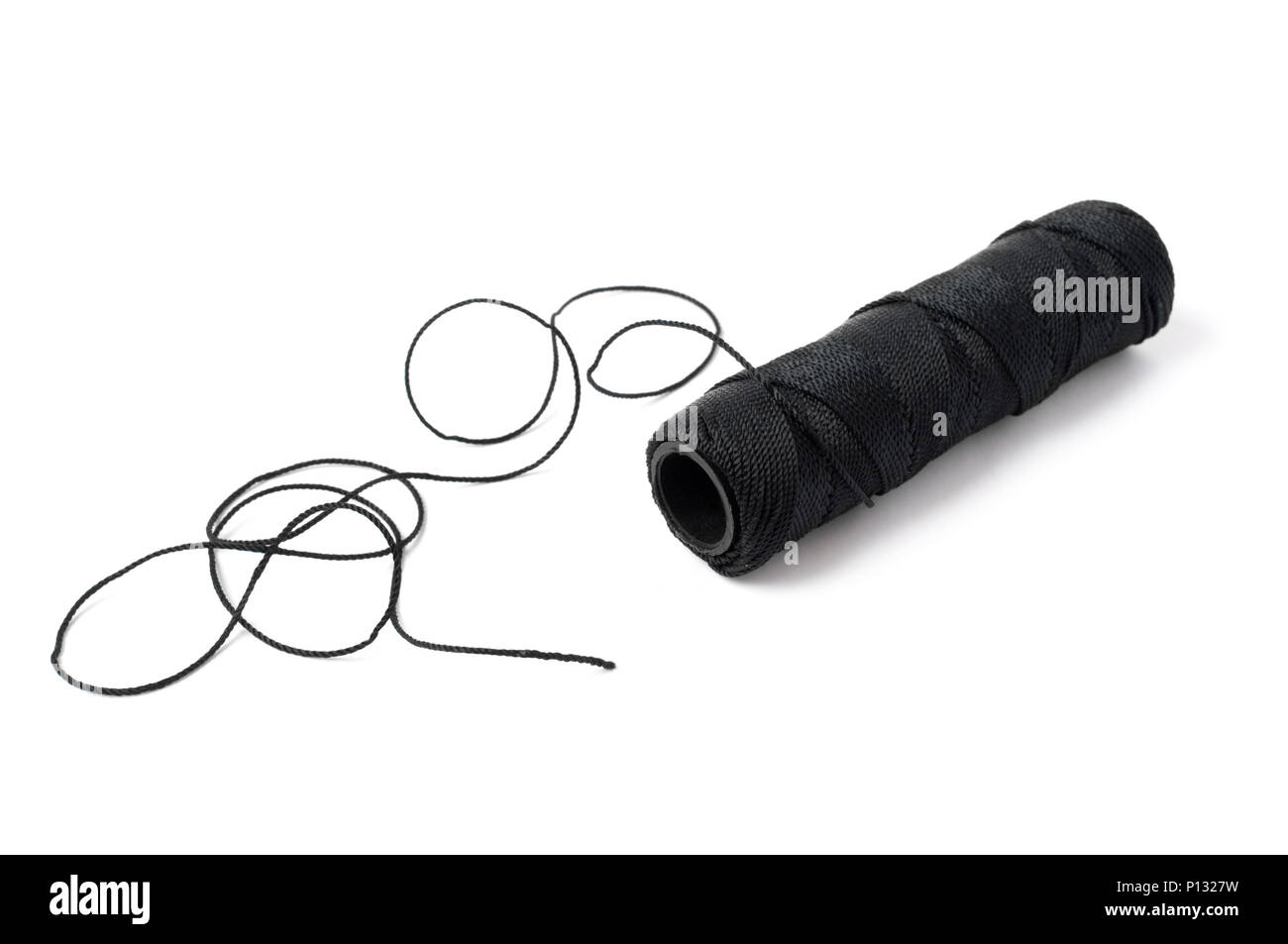 Spool of black string on white background Stock Photo - Alamy