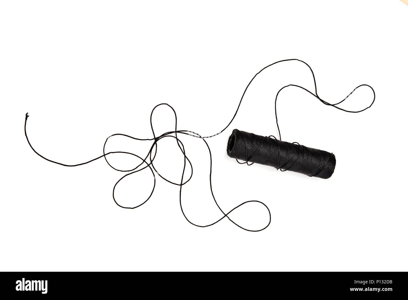 Spool of black string on white background Stock Photo - Alamy