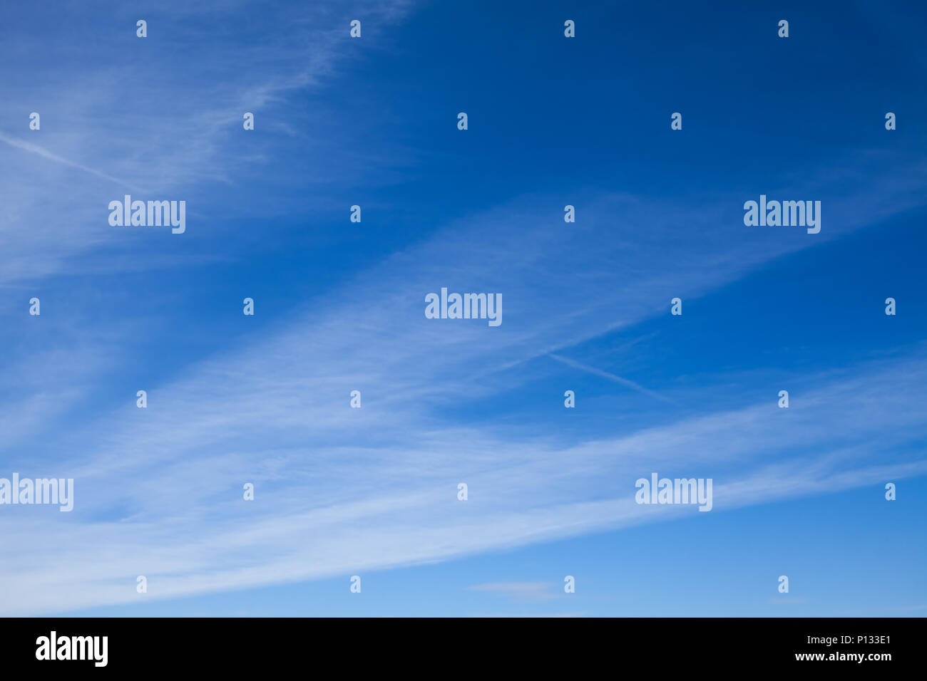 Blue sky with striped clouds. Contrail Stock Photo - Alamy