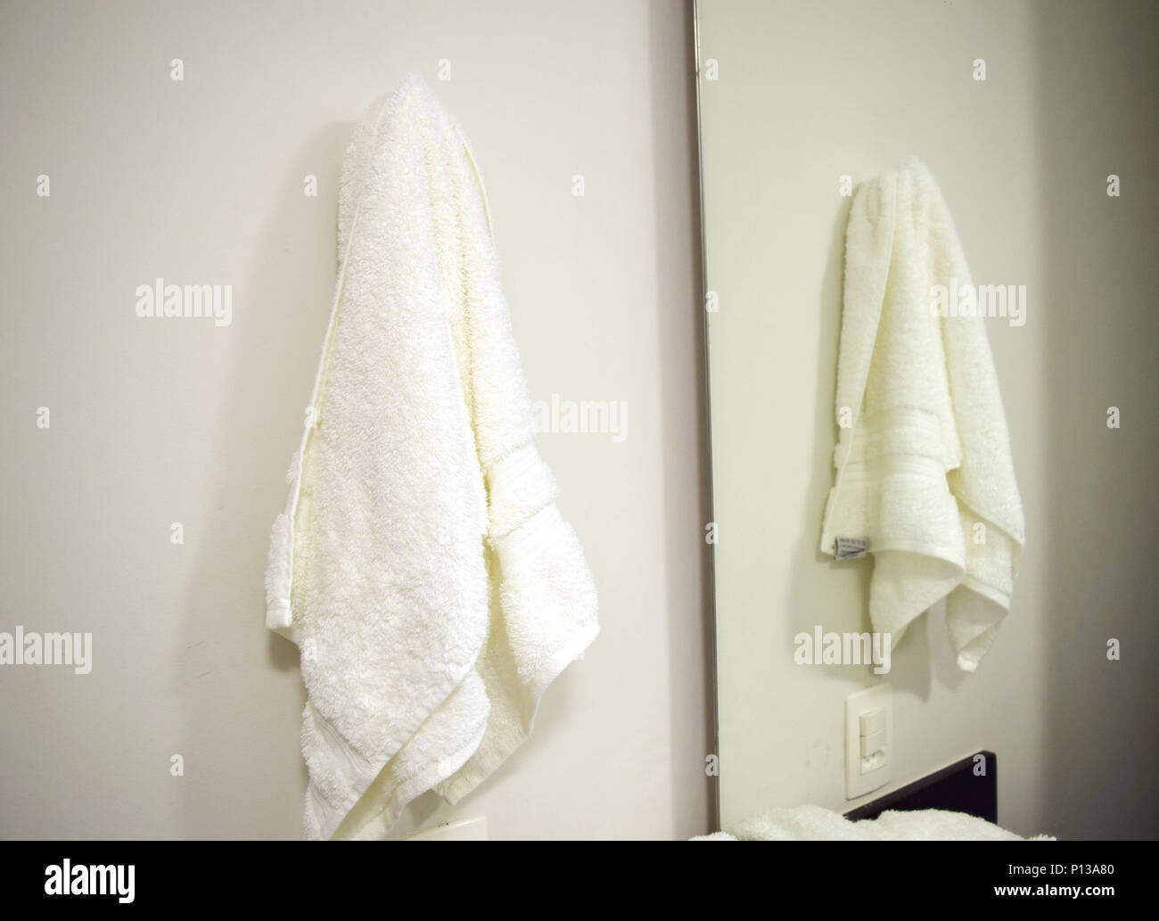 White towel hanging in bathroom on the wall across from mirror Stock ...