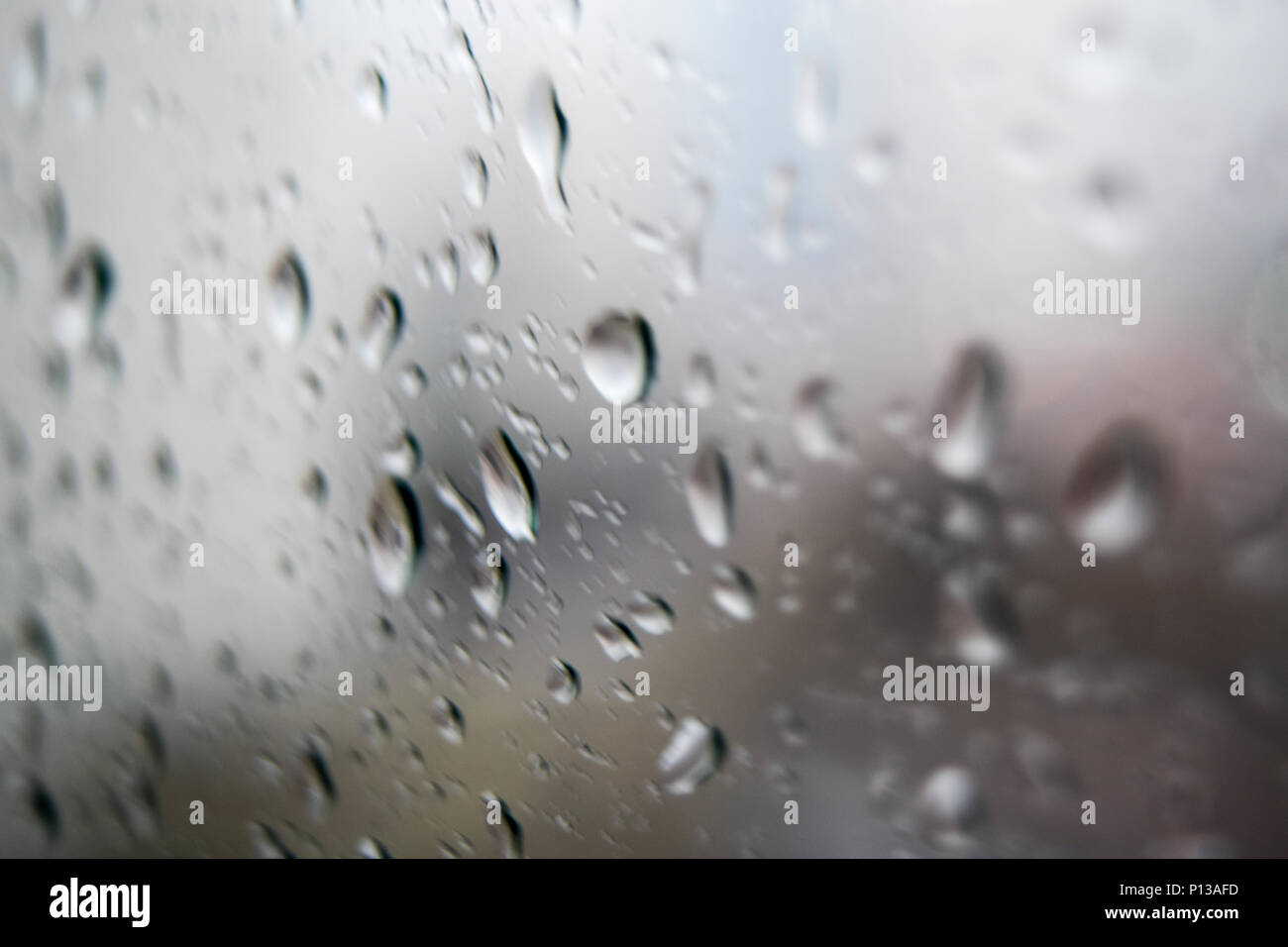 Closeup of raindrops on window in front of city background Stock Photo ...