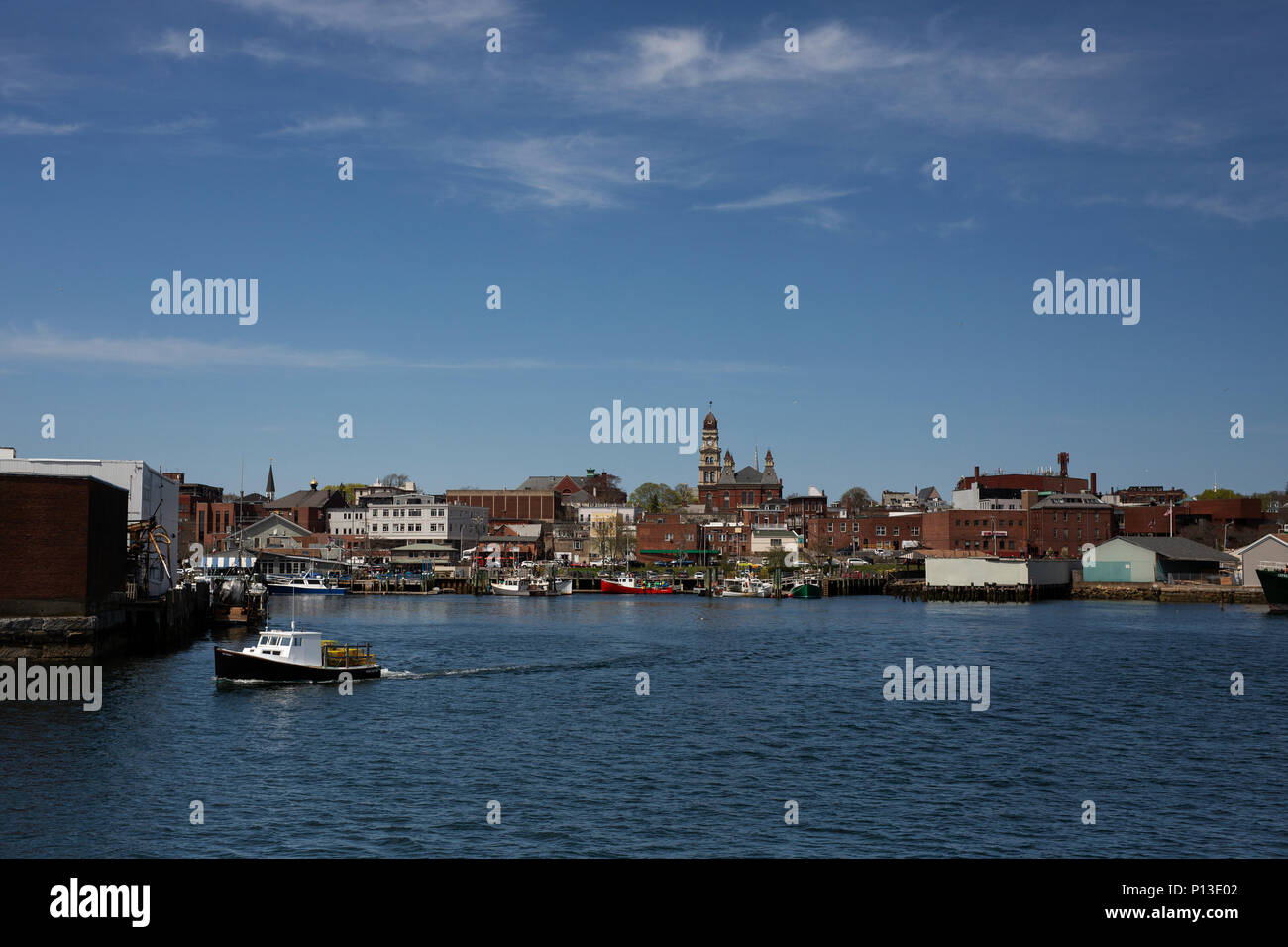 A fishing boat heads out to sea from the Inner Harbor of Gloucester ...