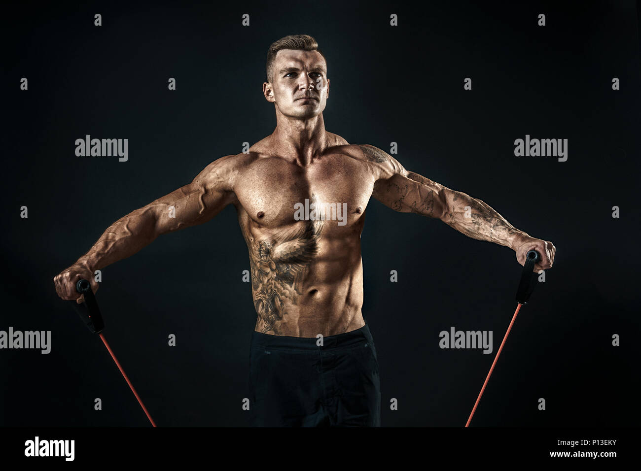 Handsome muscular strong man doing pulling exercise and working hard ...