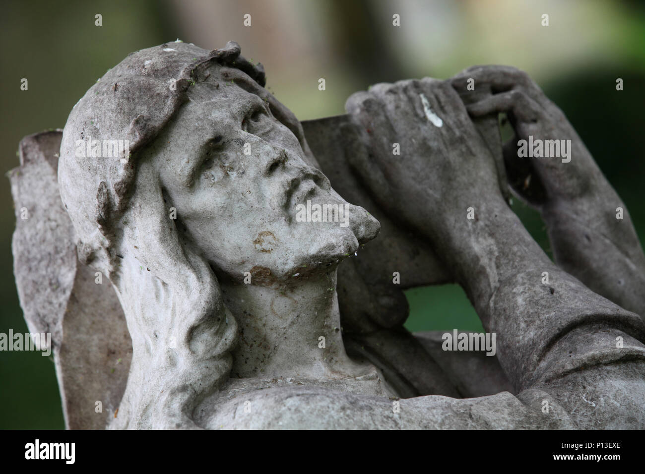 A close up of the face of a statue of a figure carrying a cross which ...
