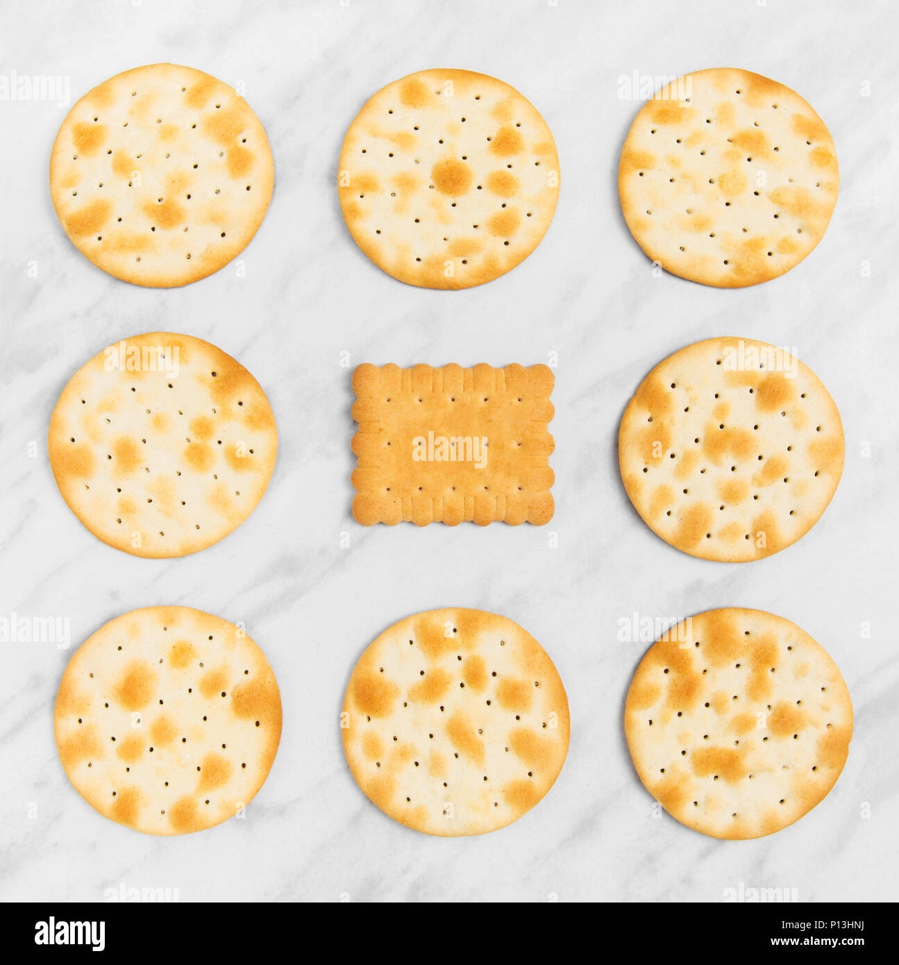 Round crackers and one square tea biscuit the middle, on marble ...