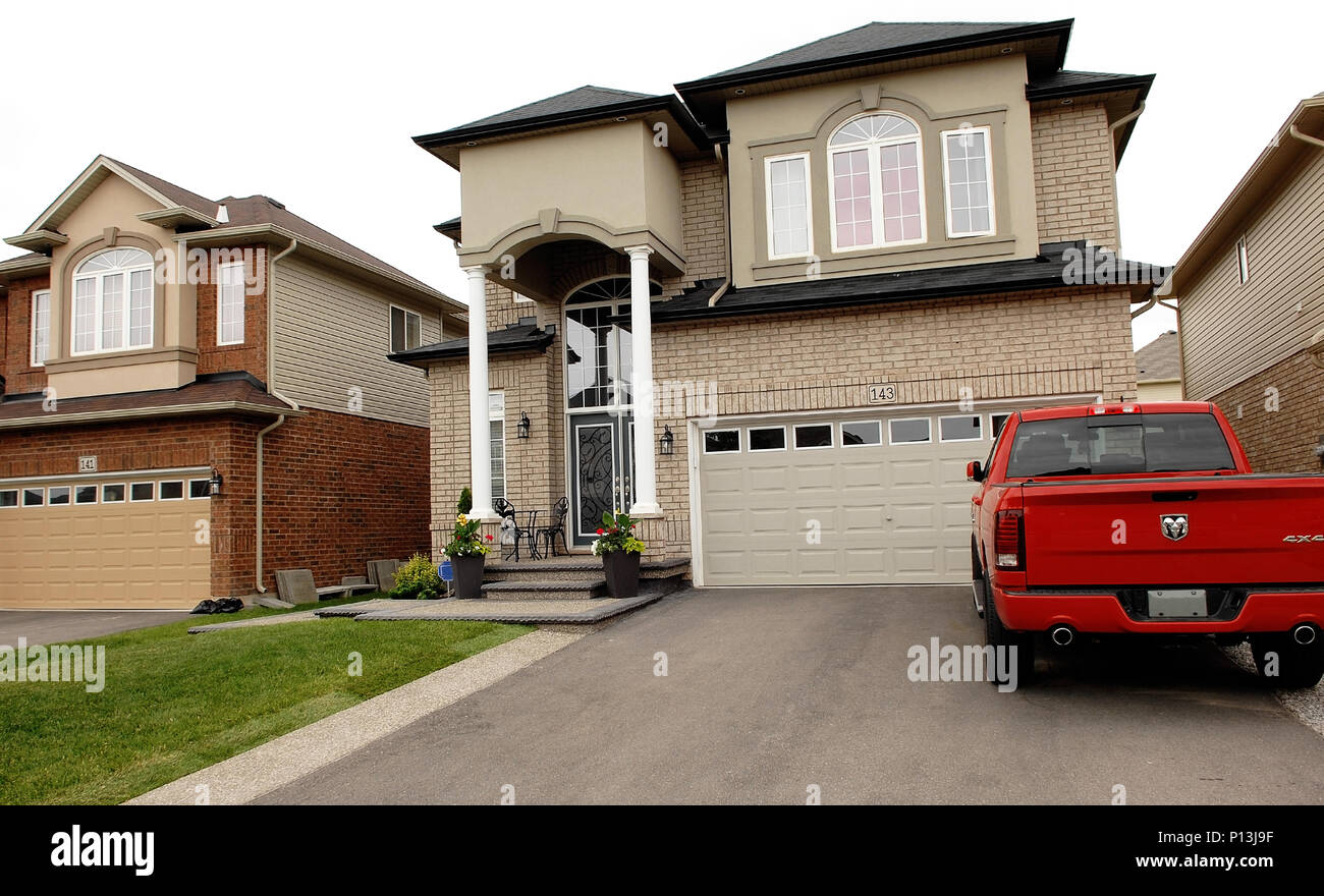 A new big house in a subdivision in Hamilton, Canada with a red truck ...