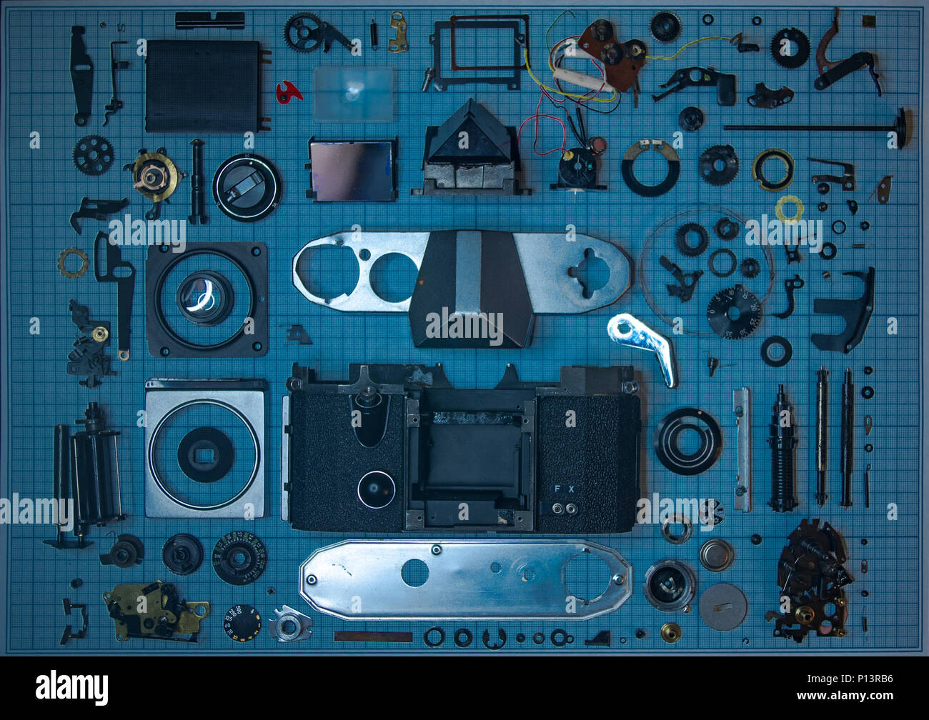parts are completely disassembled old retro film SLR camera on graph ...