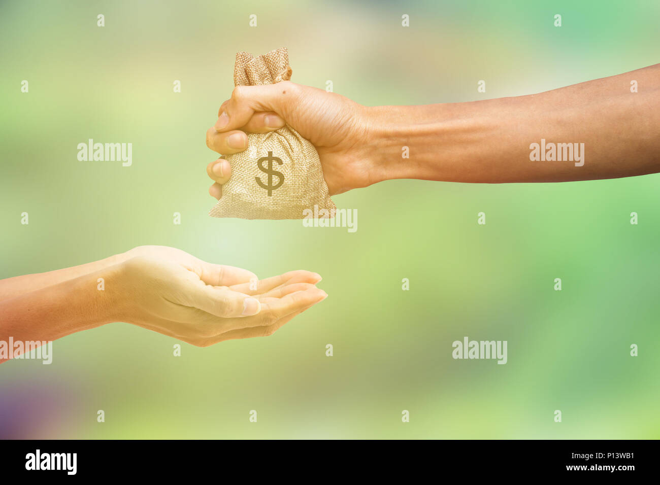 Man hand holding money bag and giving money to another person on ...