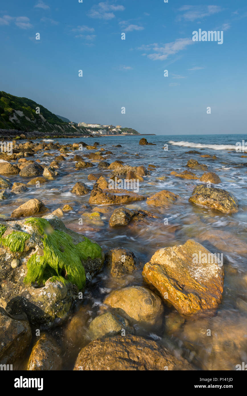 a beautiful and atmospheric seascape of the rocky foreshore, beach and ...