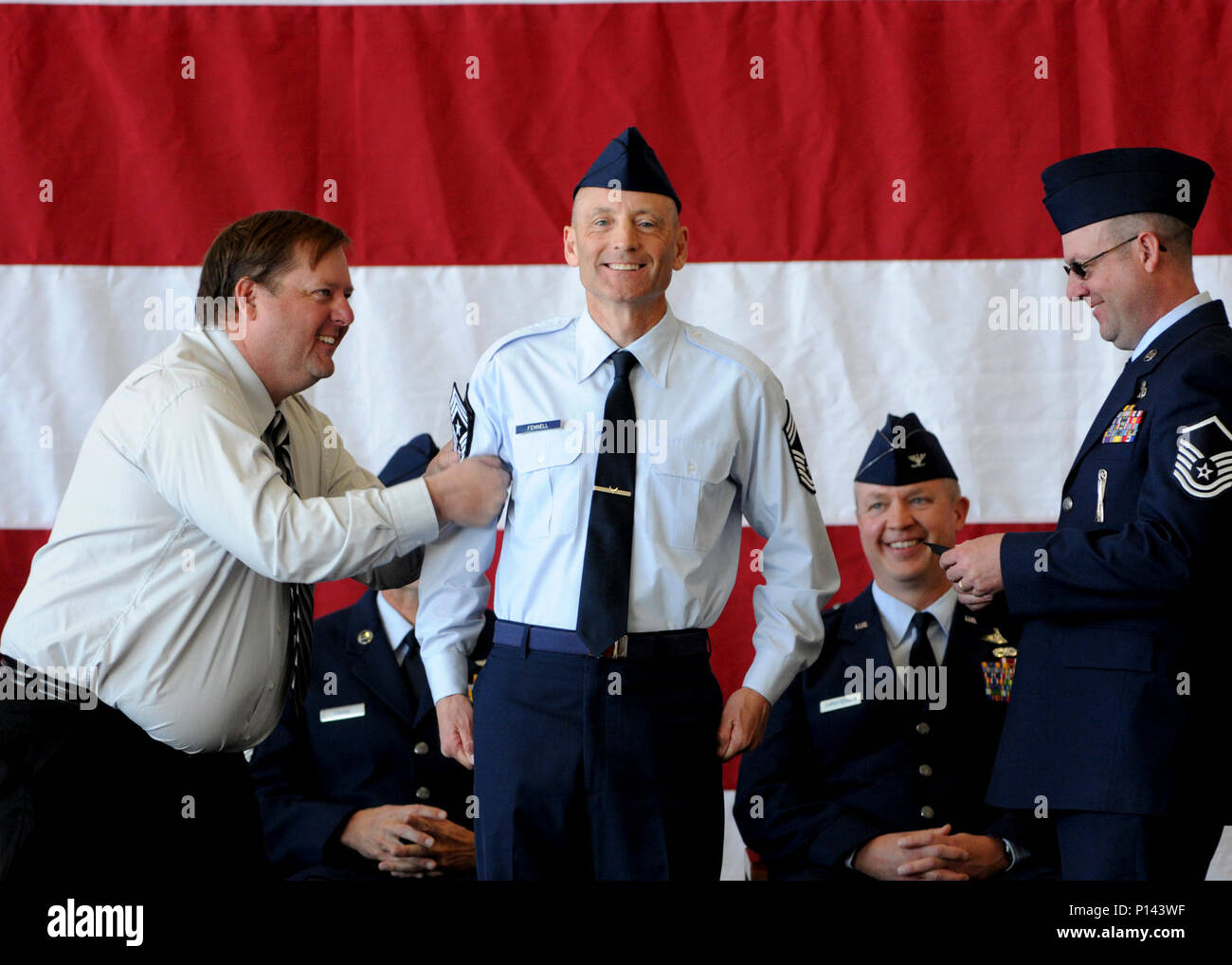 Chief Master Sgt. Thomas Fennell receives his new stripes with a punch ...
