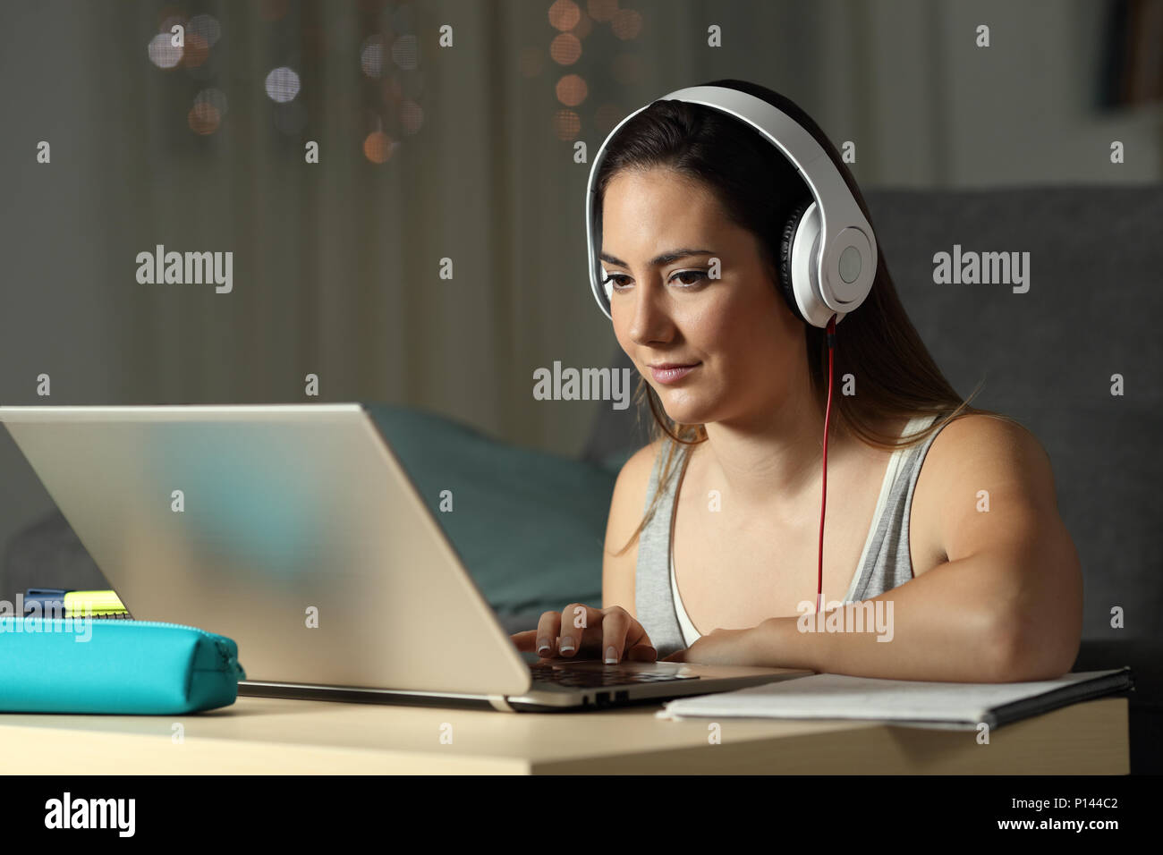 Student elearning wearing headphones watching online tutorials in the ...