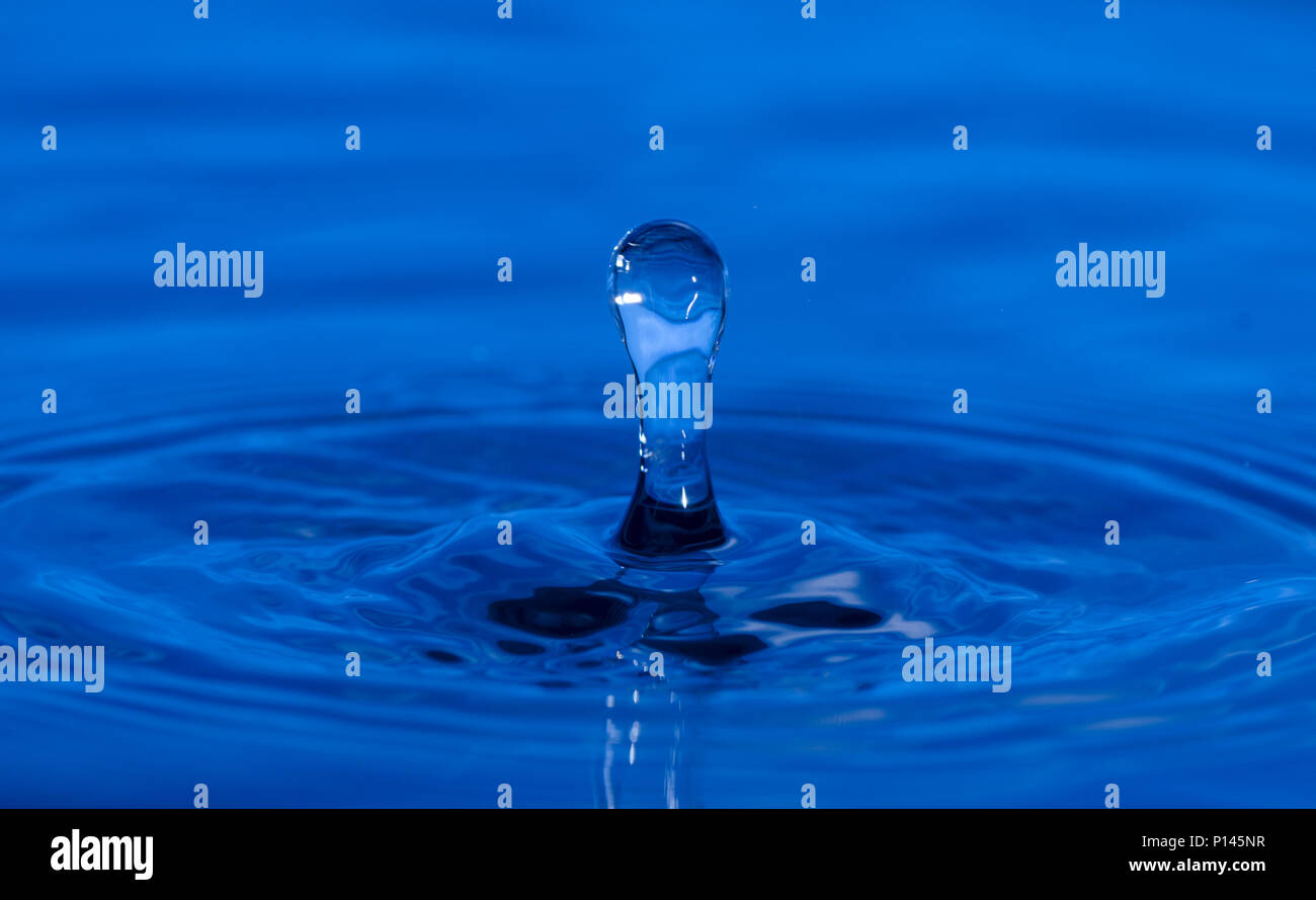 Drop of water in blue color Stock Photo - Alamy