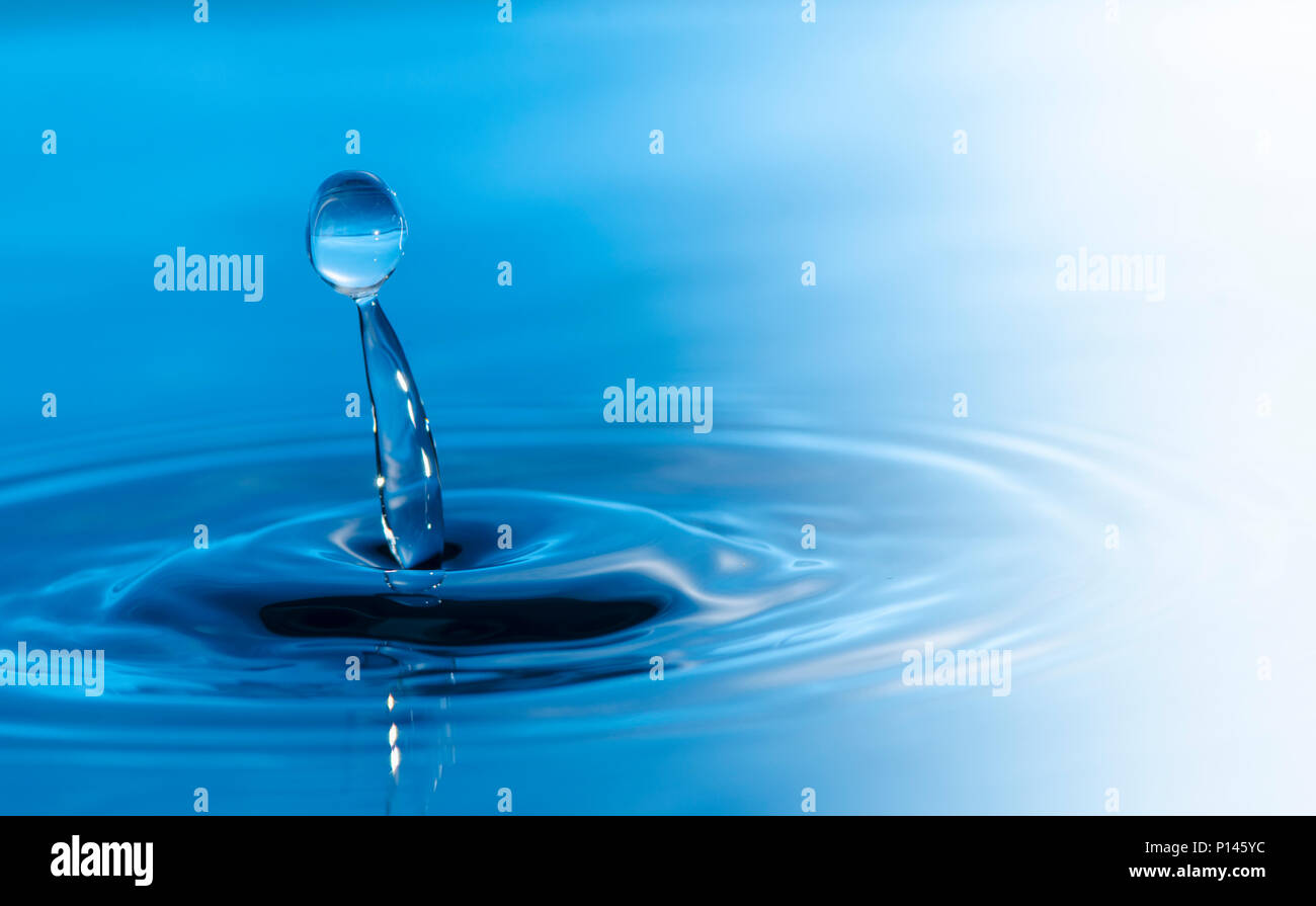 Drop of water in blue color Stock Photo - Alamy