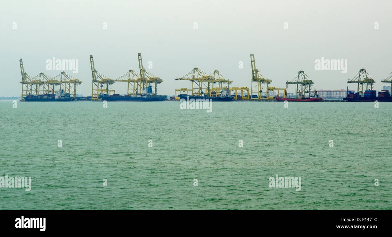 Containers loading at sea trading port Stock Photo - Alamy