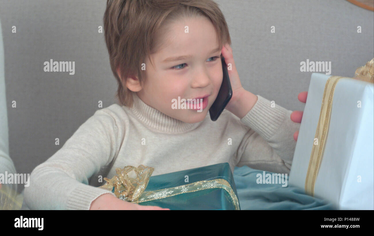 Little boy talking on the phone describing presents he got for ...