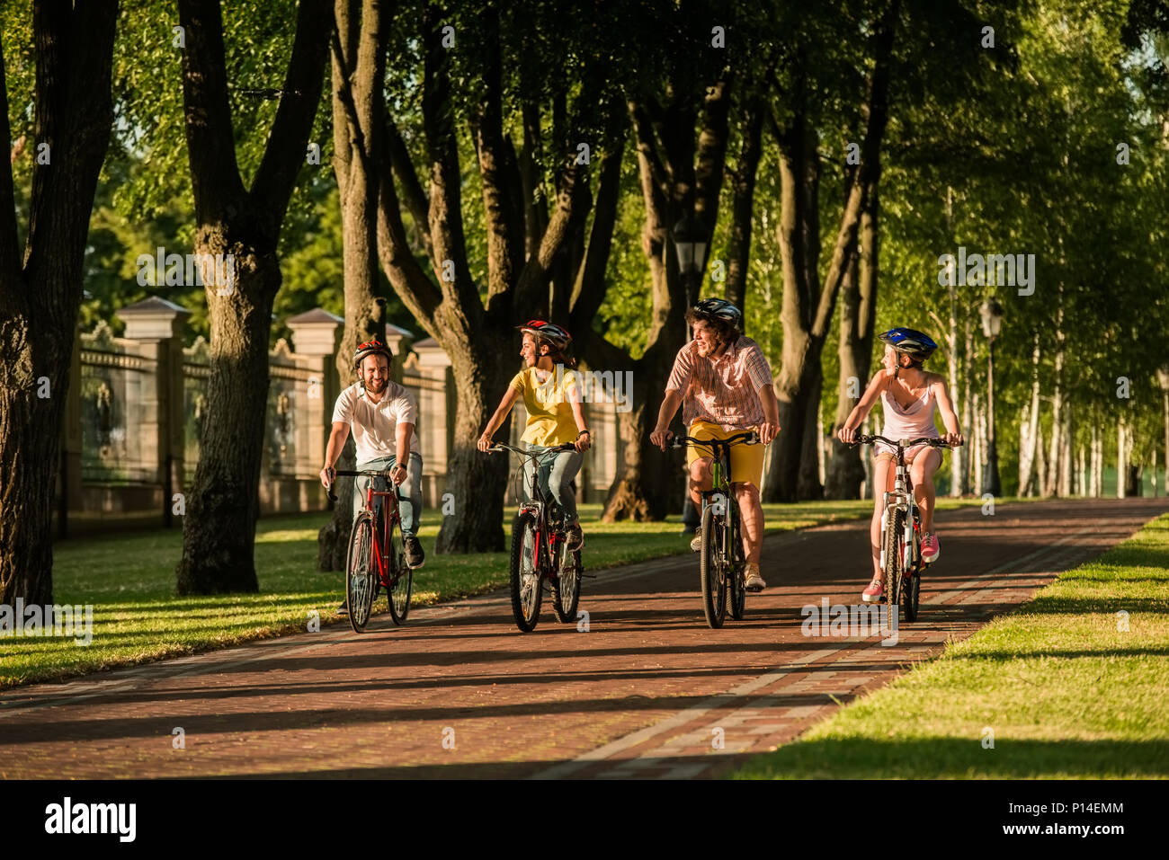 Young sporty active people biking in park. Group of friends having fun ...