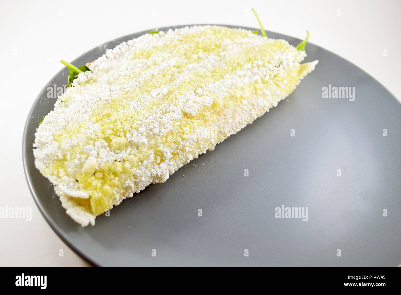 Brazilian tapioca on a plate filled with cheese, tomato, arugula, and ...