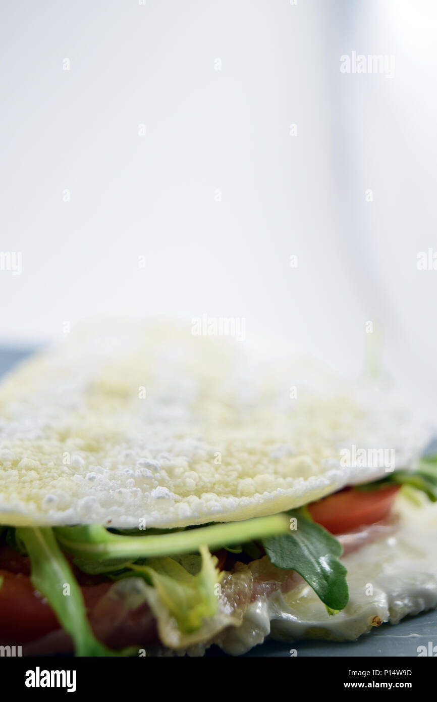 Brazilian tapioca on a plate filled with cheese, tomato, arugula, and ...