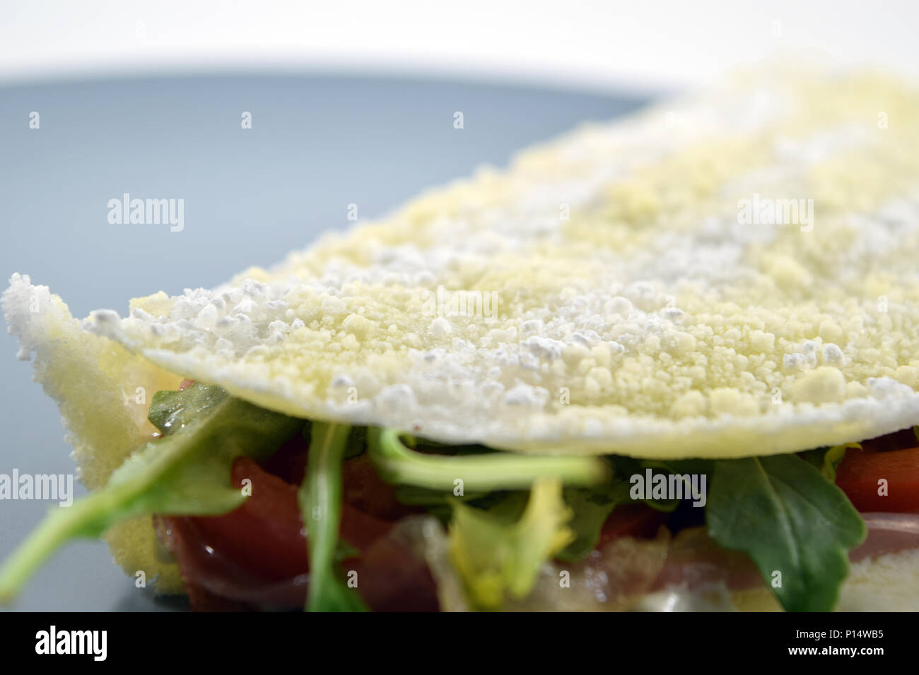 Brazilian tapioca on a plate filled with cheese, tomato, arugula, and ...