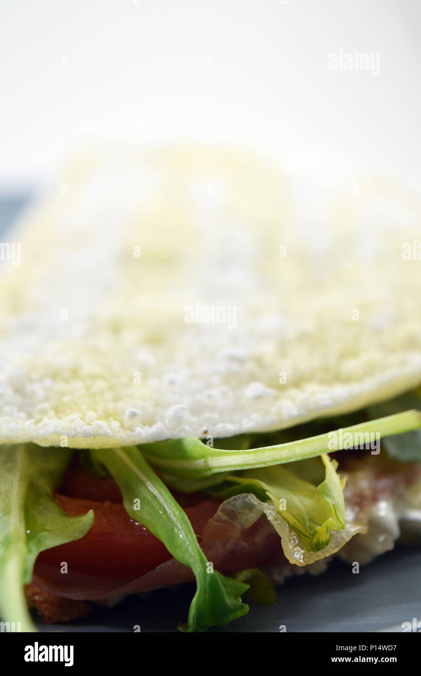 Brazilian tapioca on a plate filled with cheese, tomato, arugula, and ...
